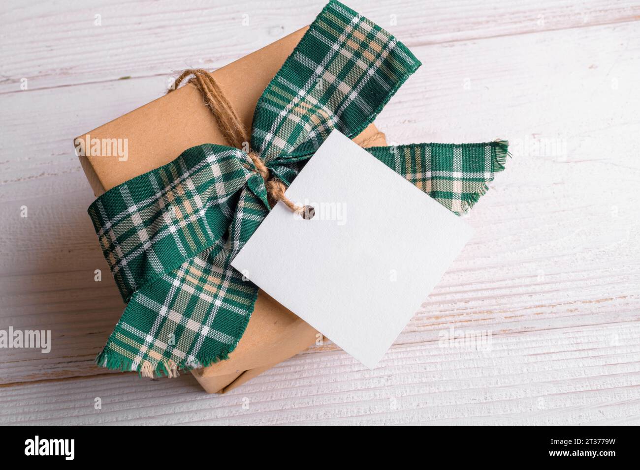 Christmas square gift tag mockup with craft wrapped gift box on a white ...