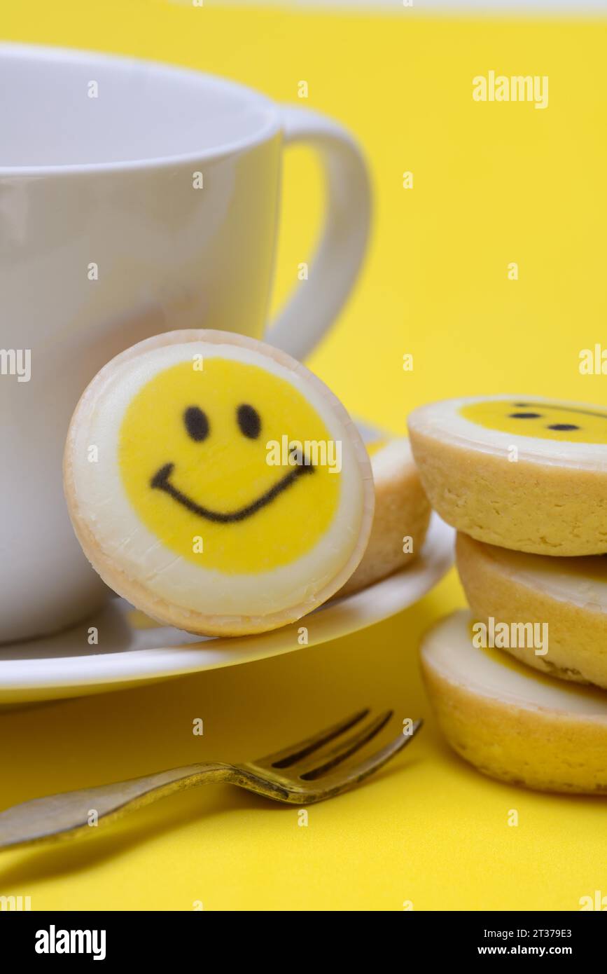 Pastry with smiley face and coffee cup, symbol Stock Photo - Alamy