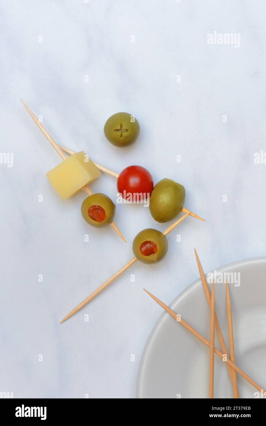 Stuffed olives on toothpicks, green olives, tomato and cheese cubes ...
