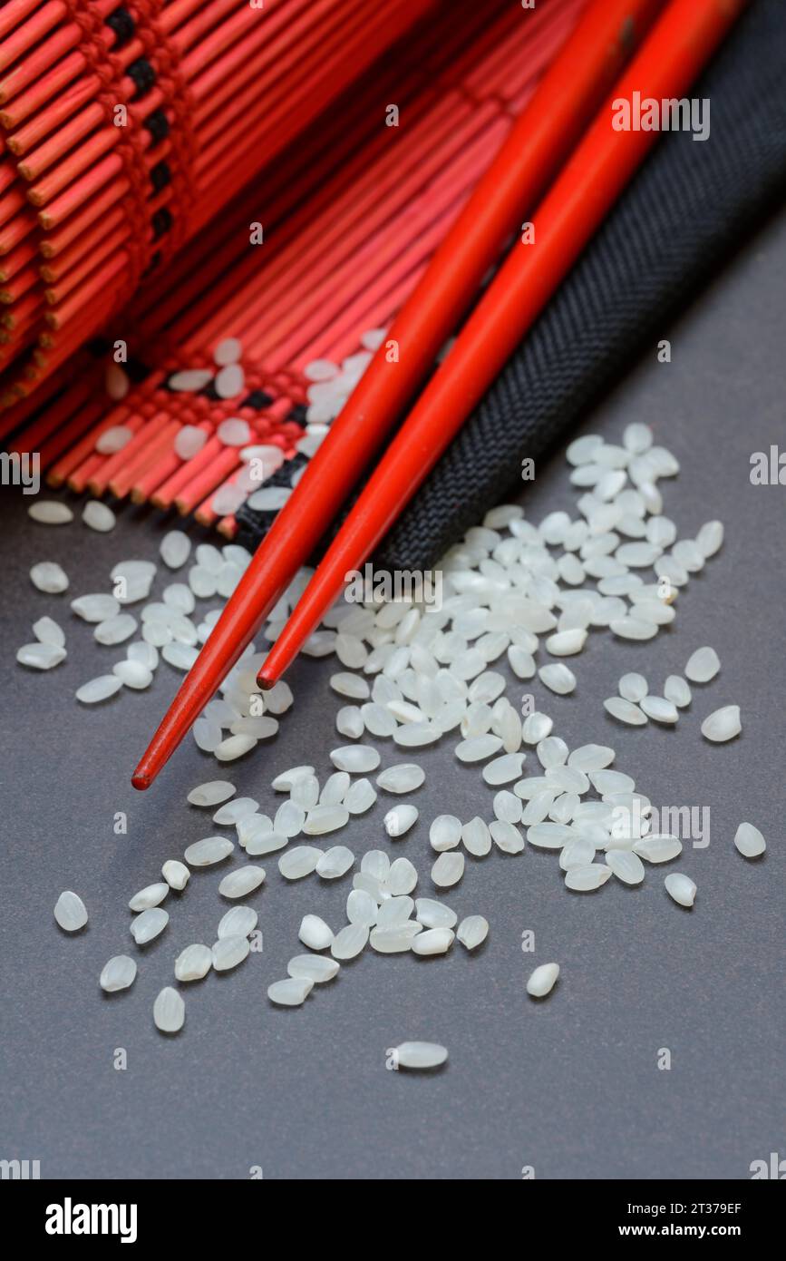 Rice, white rice grains and chopsticks with bamboo mat Stock Photo - Alamy