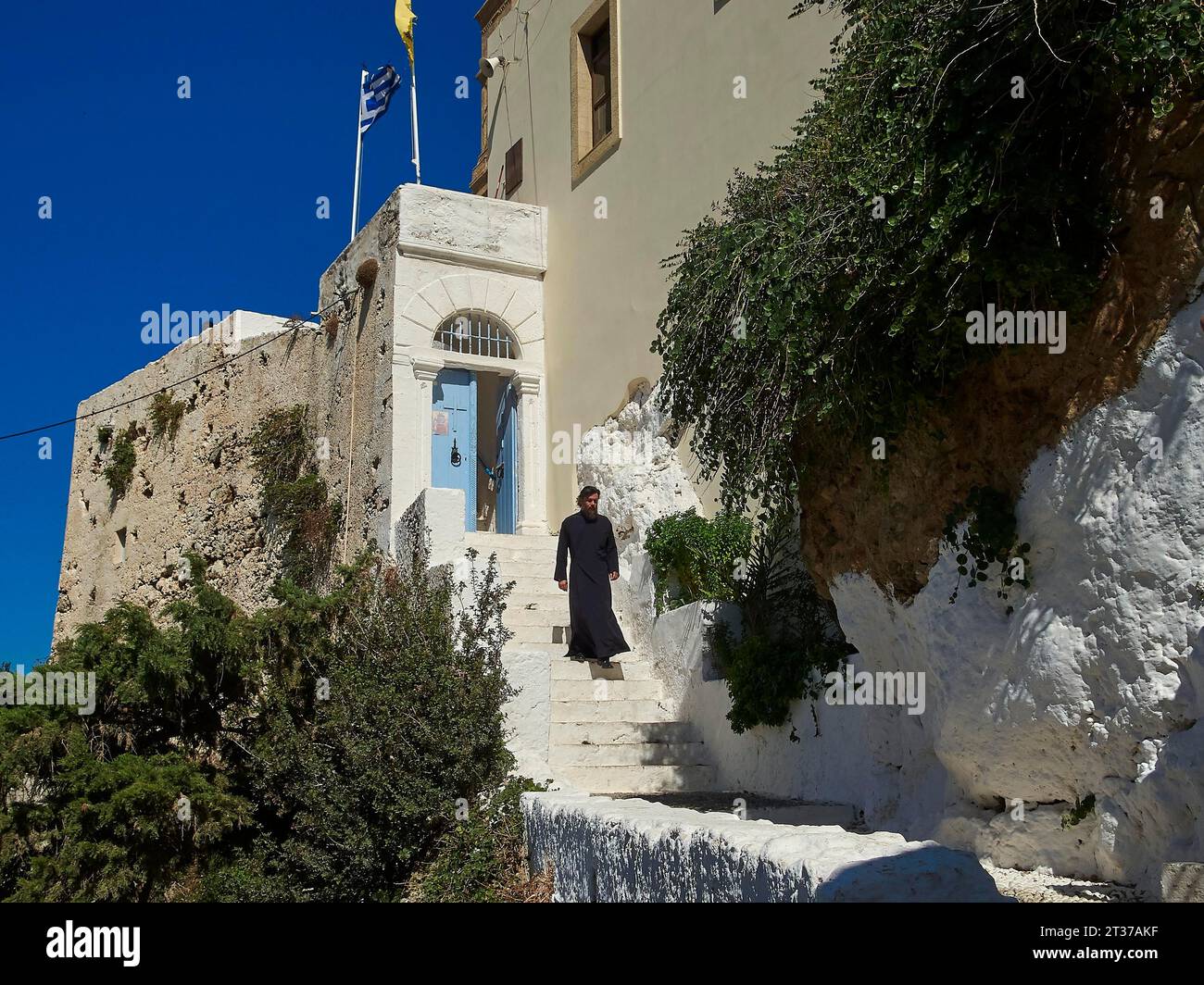 Stairs, young monk dressed in black on stairs, blue entrance door ...