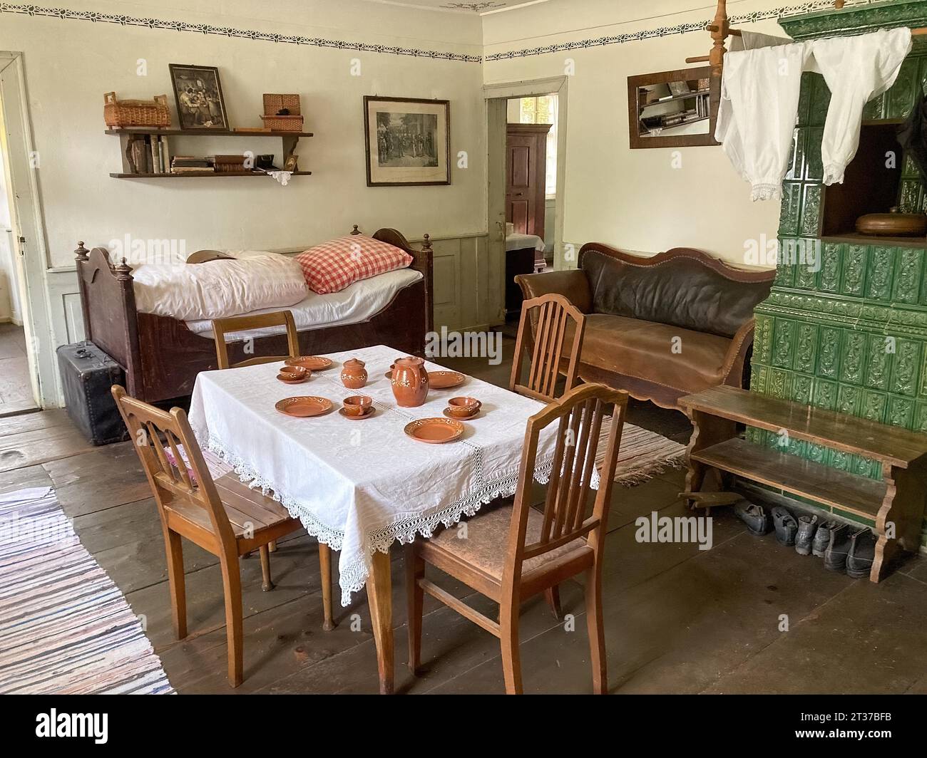 Room with dining table simple earthenware dishes four chairs bed ...