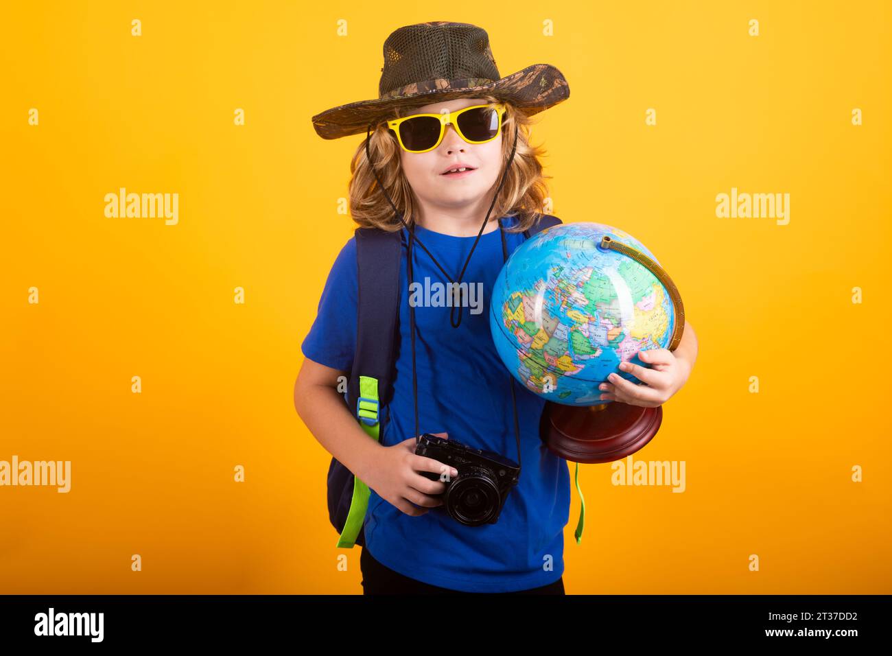 Studio portrait on a yellow background. Kid with earth planet model ...