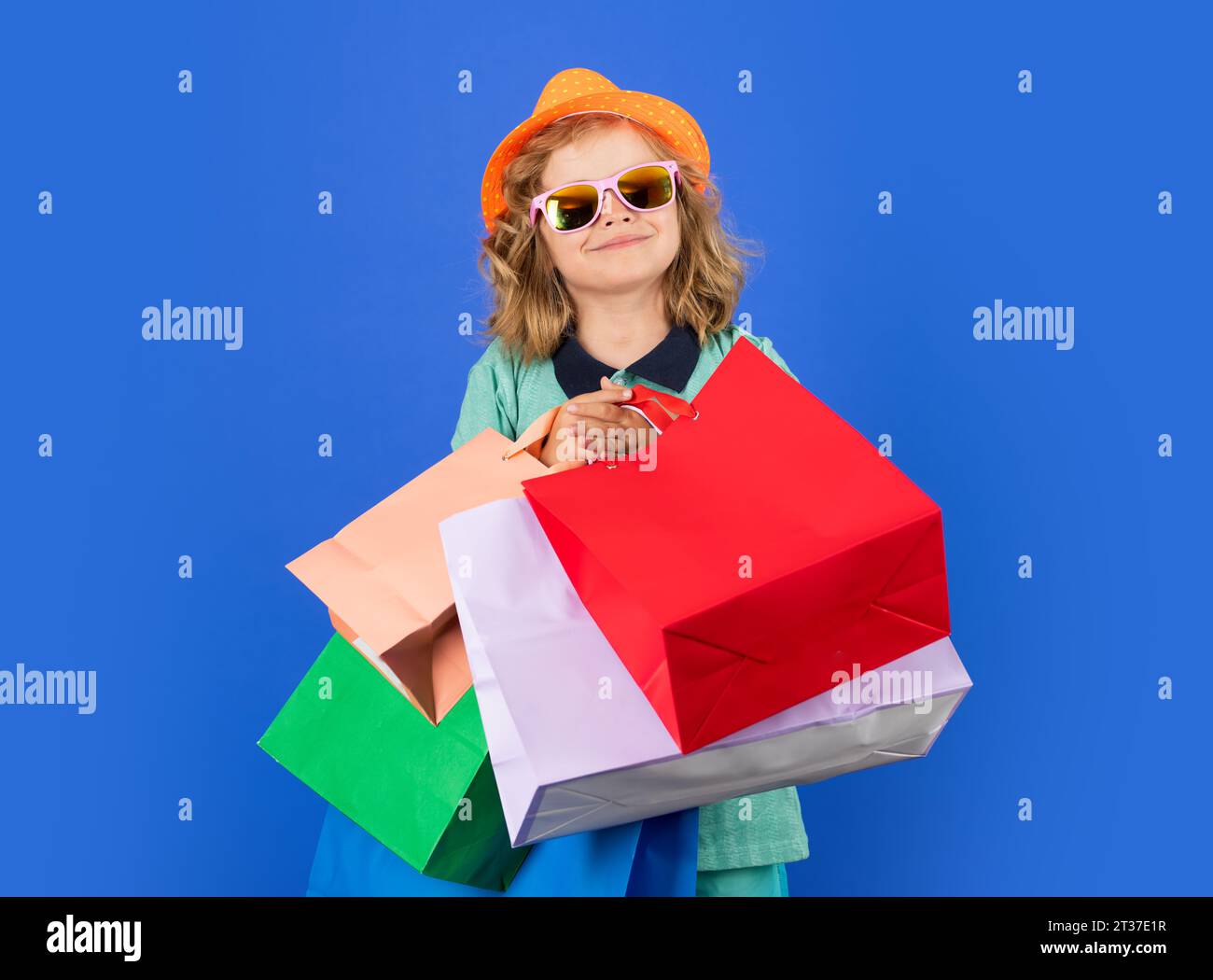 Discounts and sales. Happy Kid boy with shopping bags. Kid with ...