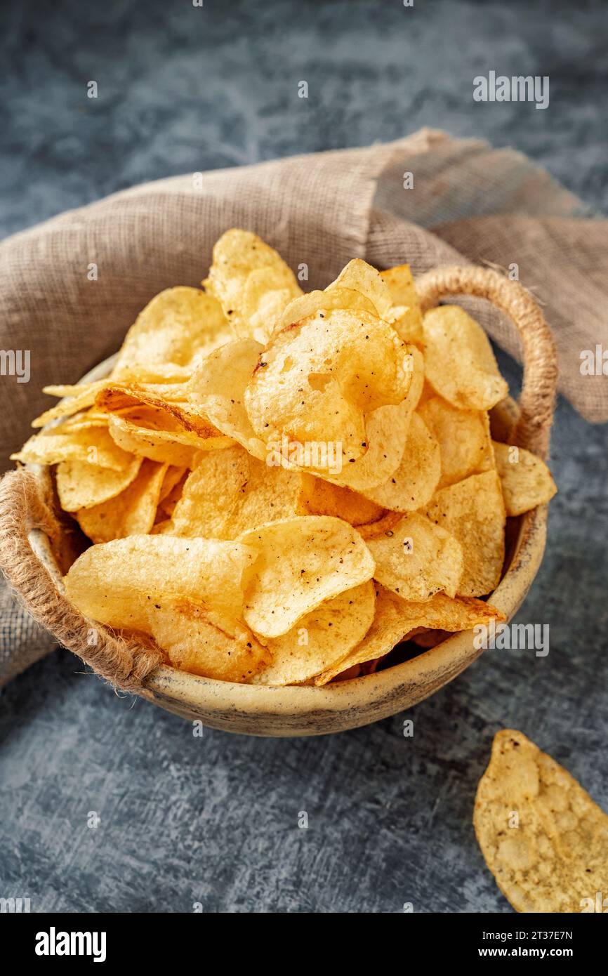 Potato chips in a handmade clay bowl. Not healthy, but tasty food Stock ...