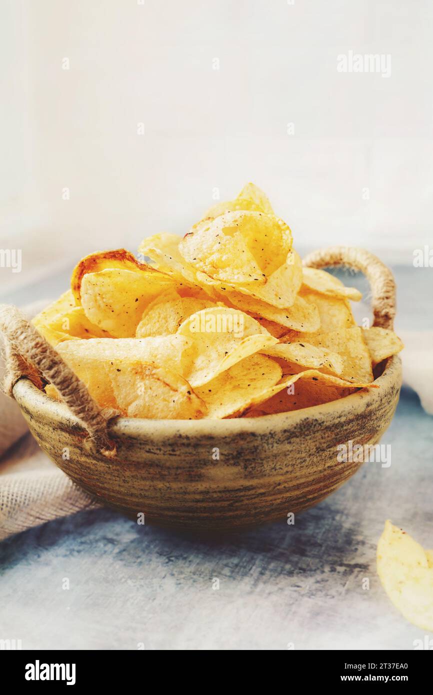 Potato chips in a handmade clay bowl. Not healthy, but tasty food Stock ...