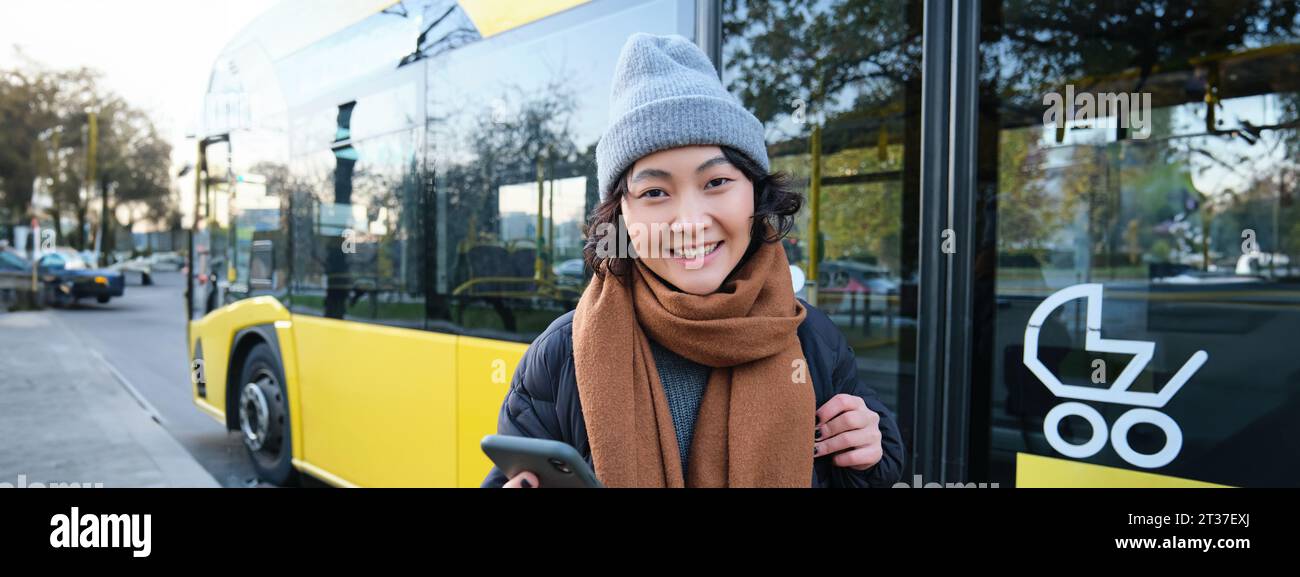 Image of girl student waiting for public transport, checks schedule on ...