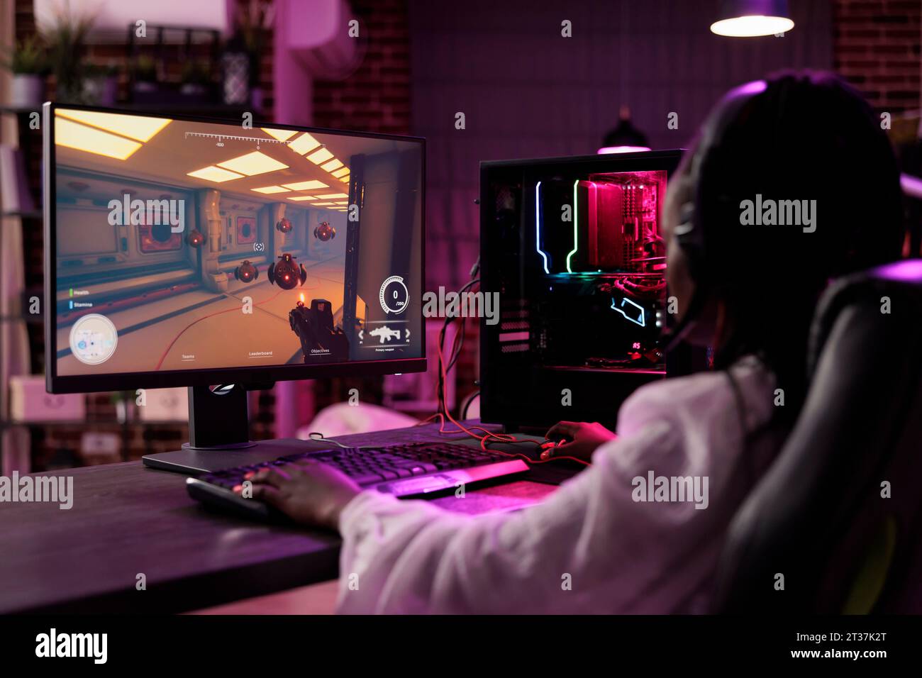 Woman in cozy apartment playing captivating video game on gaming PC at ...