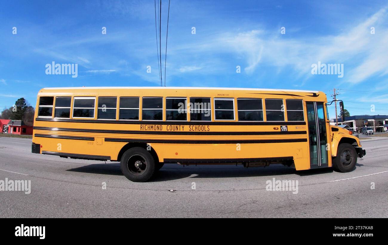 Augusta, Ga USA - 01 19 22: POV Driving street pan yellow school bus ...