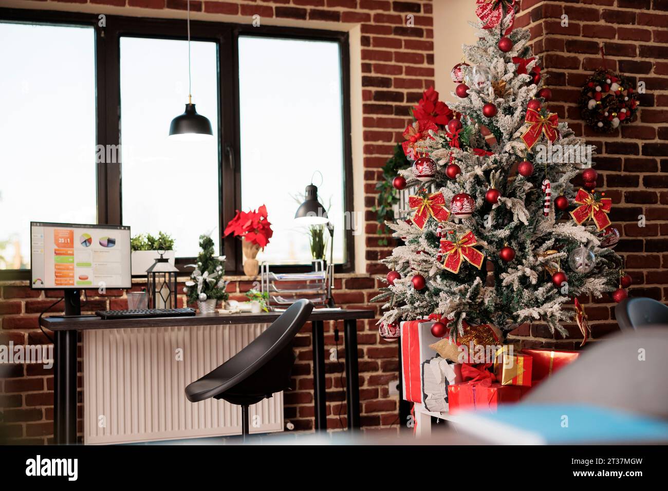 Decorated office workspace with festive christmas tree and presents ...