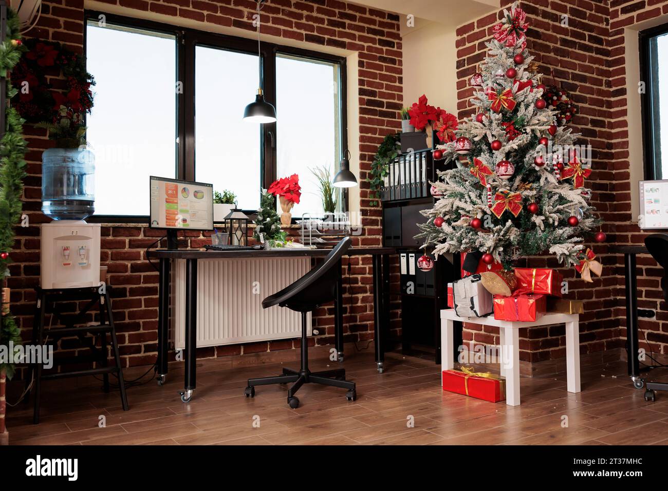 Decorated empty office space with christmas fir tree, gifts and festive ...