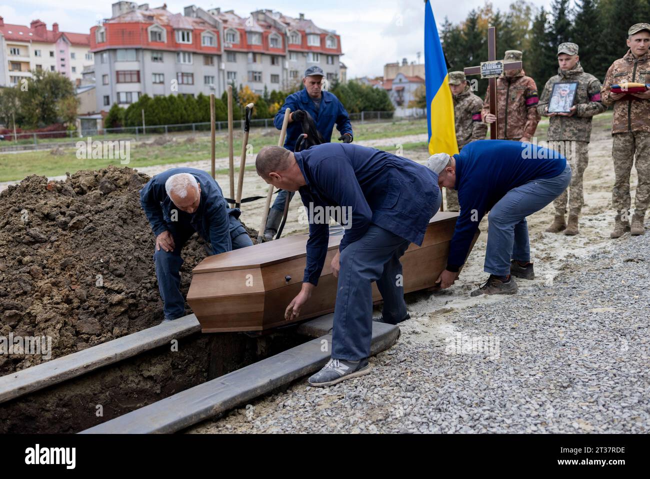Workers at the cemetery seen lowering the coffin of the fallen ...
