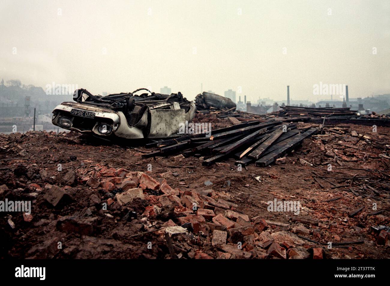 Upturned wrecked abandoned car on a wasteland of brick rubble during ...