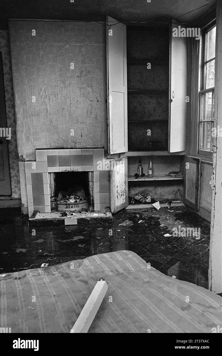 Flooded backroom of a house with a mattress, fireplace and rubbish ...