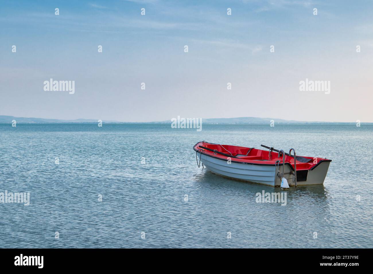 A small vessel floating in the ocean against a clear blue sky Stock ...