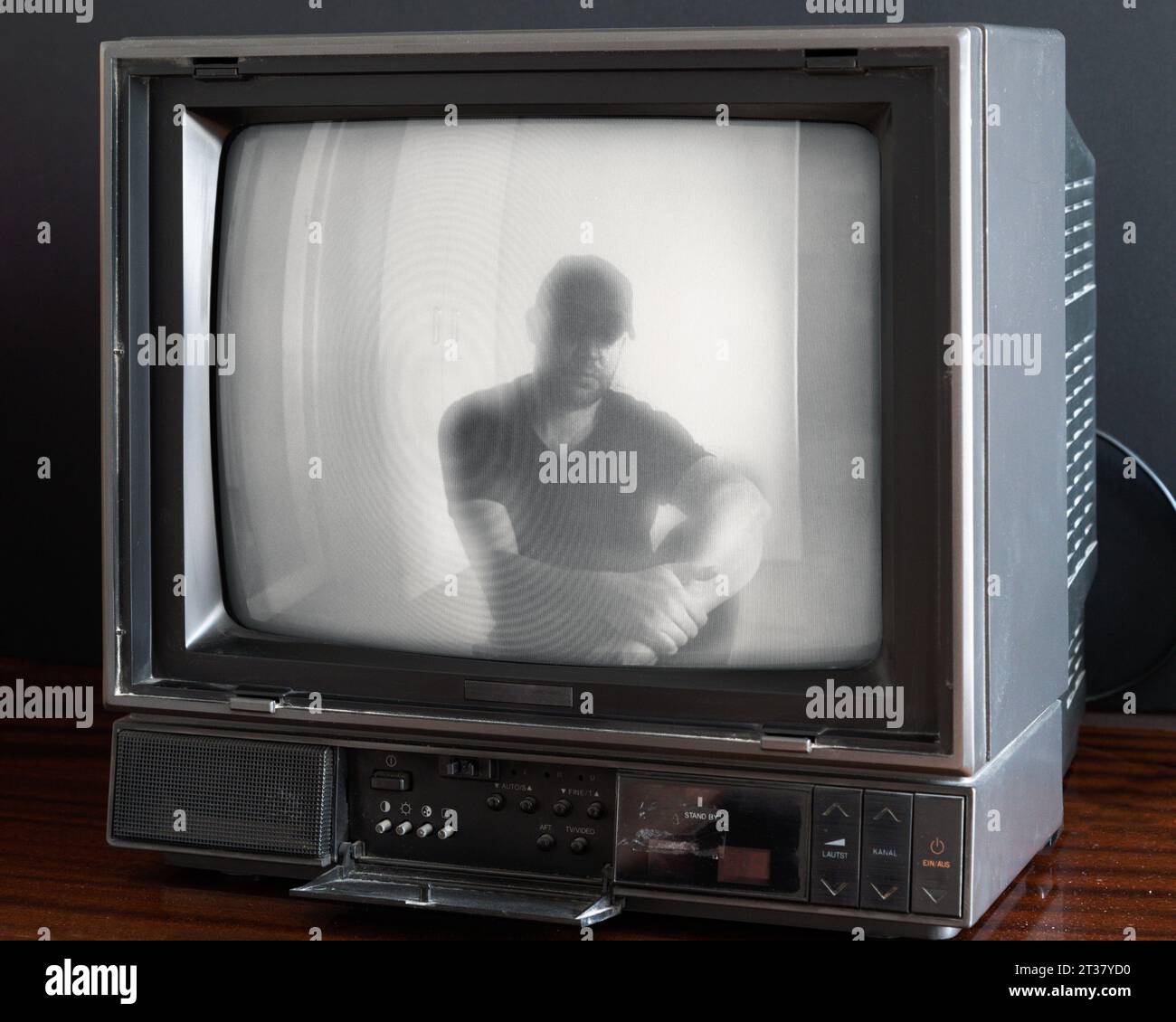 An antique television set with a silhouette of a person with a detailed ...