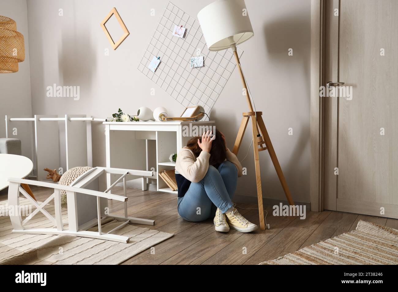 Young woman sitting near table during earthquake at home Stock Photo ...