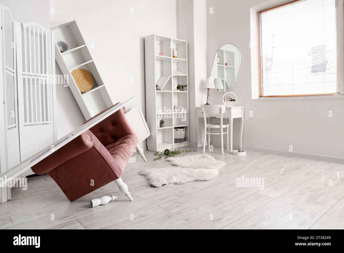 Armchair with folding screen and dressing table in messy room Stock ...