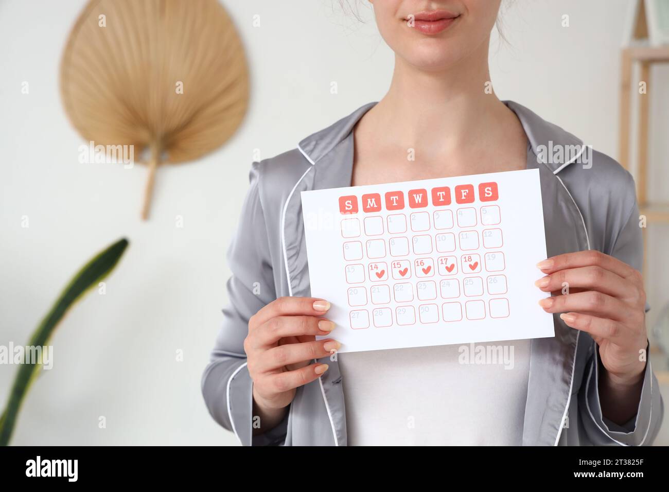 Young woman with menstrual calendar in bathroom Stock Photo - Alamy
