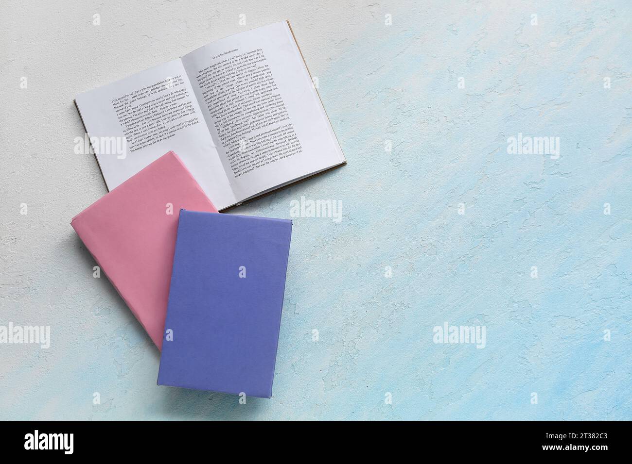 Open and closed books on light blue background Stock Photo - Alamy