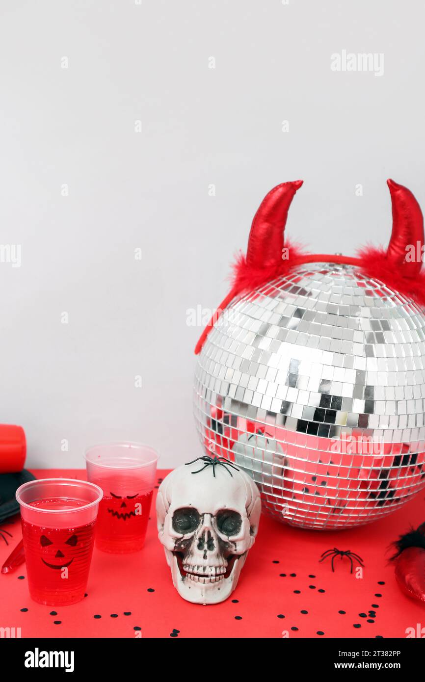 Halloween party composition with punch, skull and disco ball on red ...