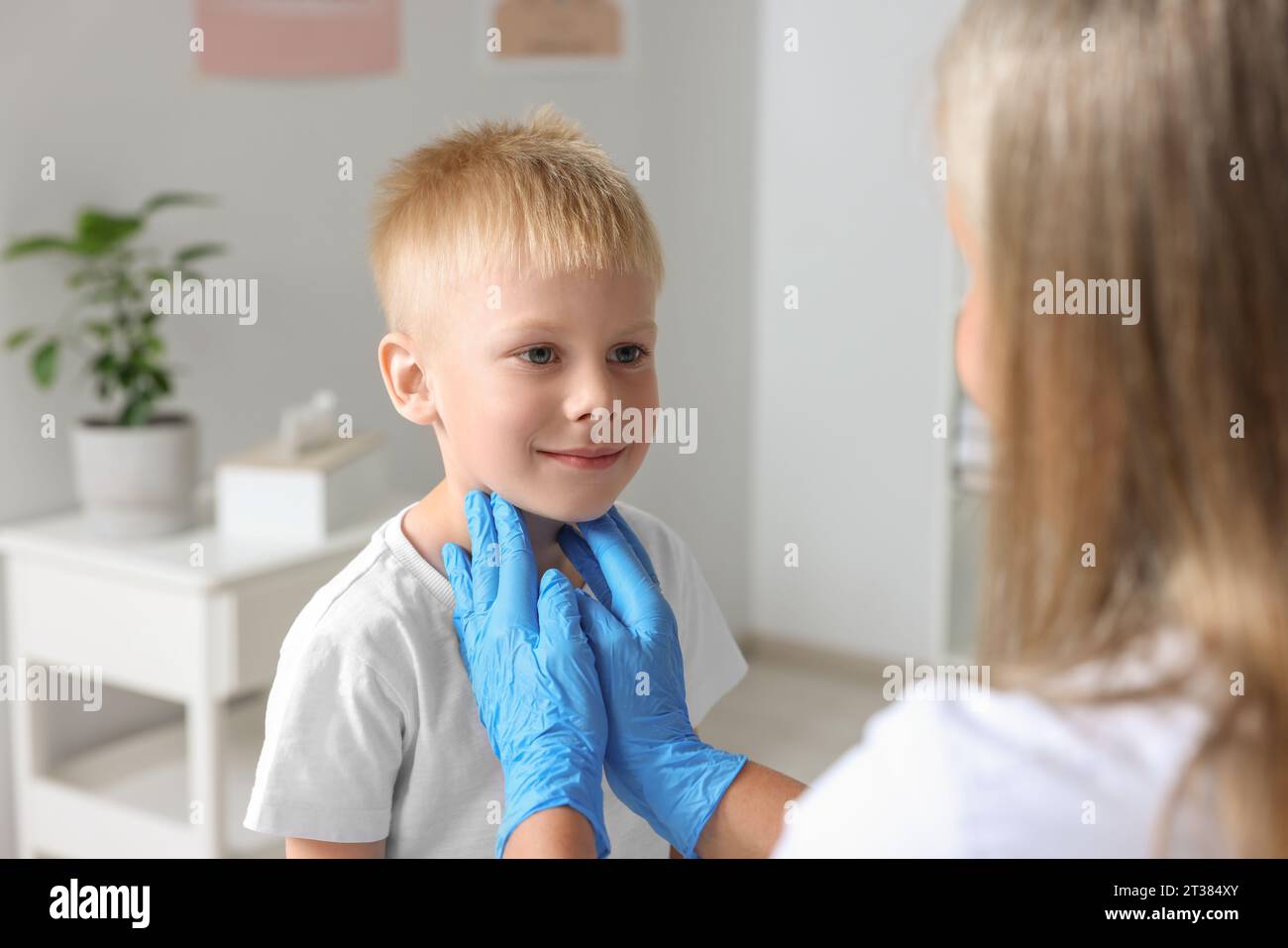 Endocrinologist examining boy's thyroid gland at hospital Stock Photo ...