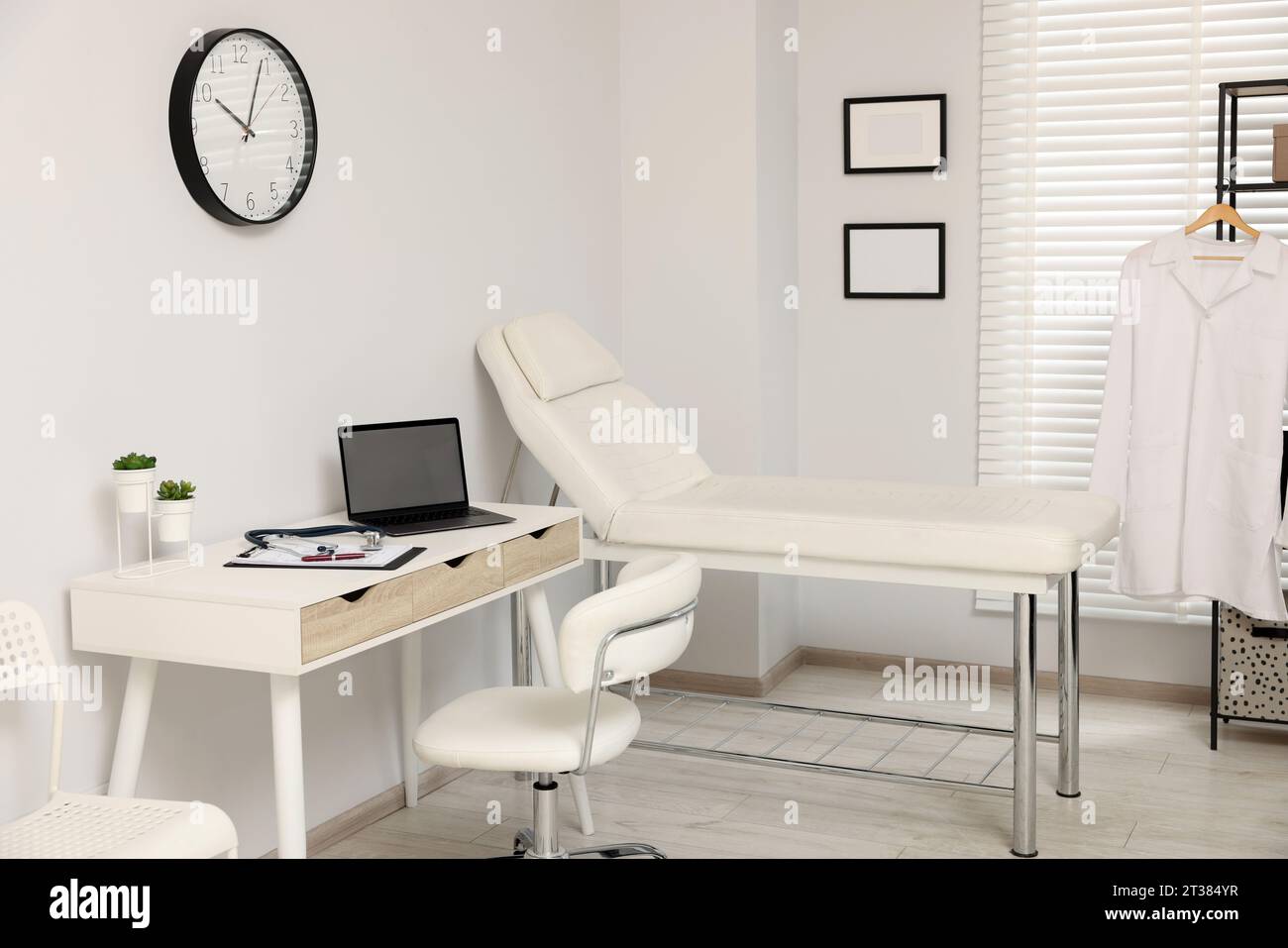 Modern medical office with doctor's workplace and examination table in ...