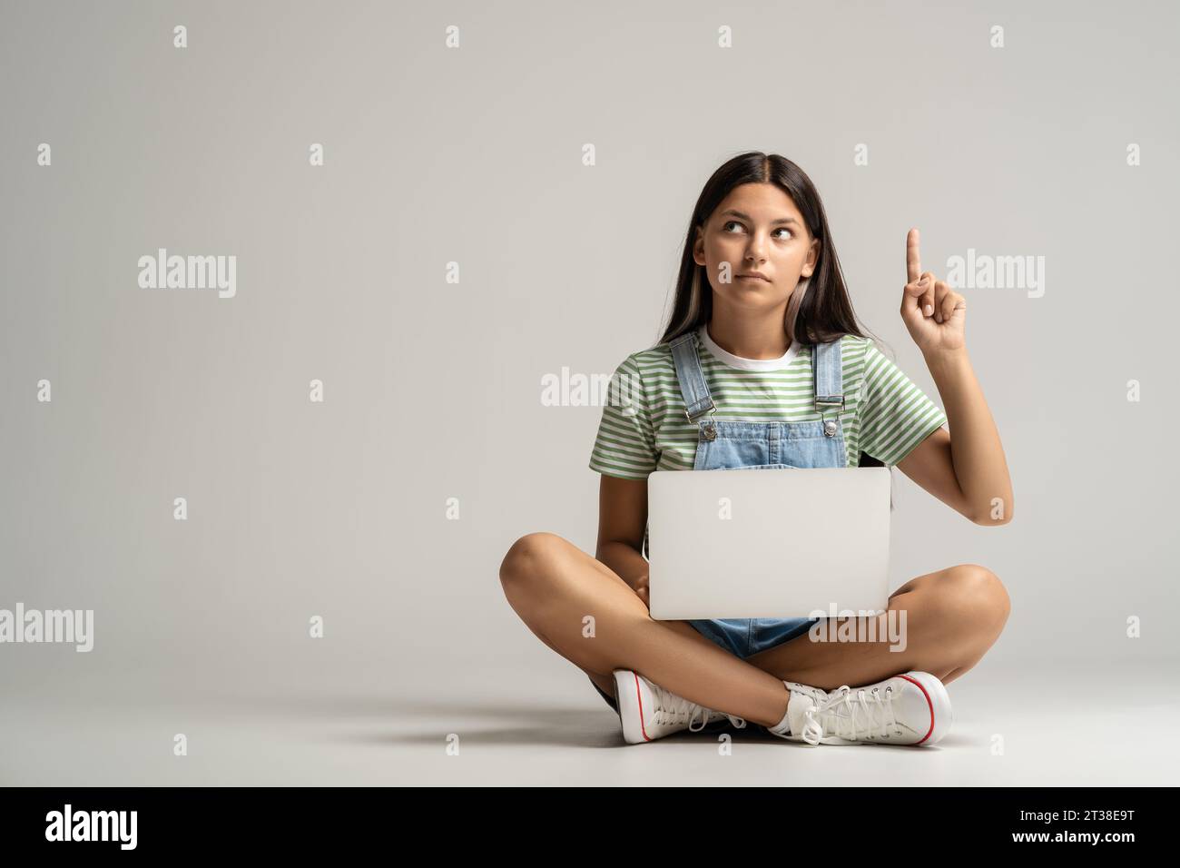 Intelligent schoolgirl pointing finger with insight gesture having good ...