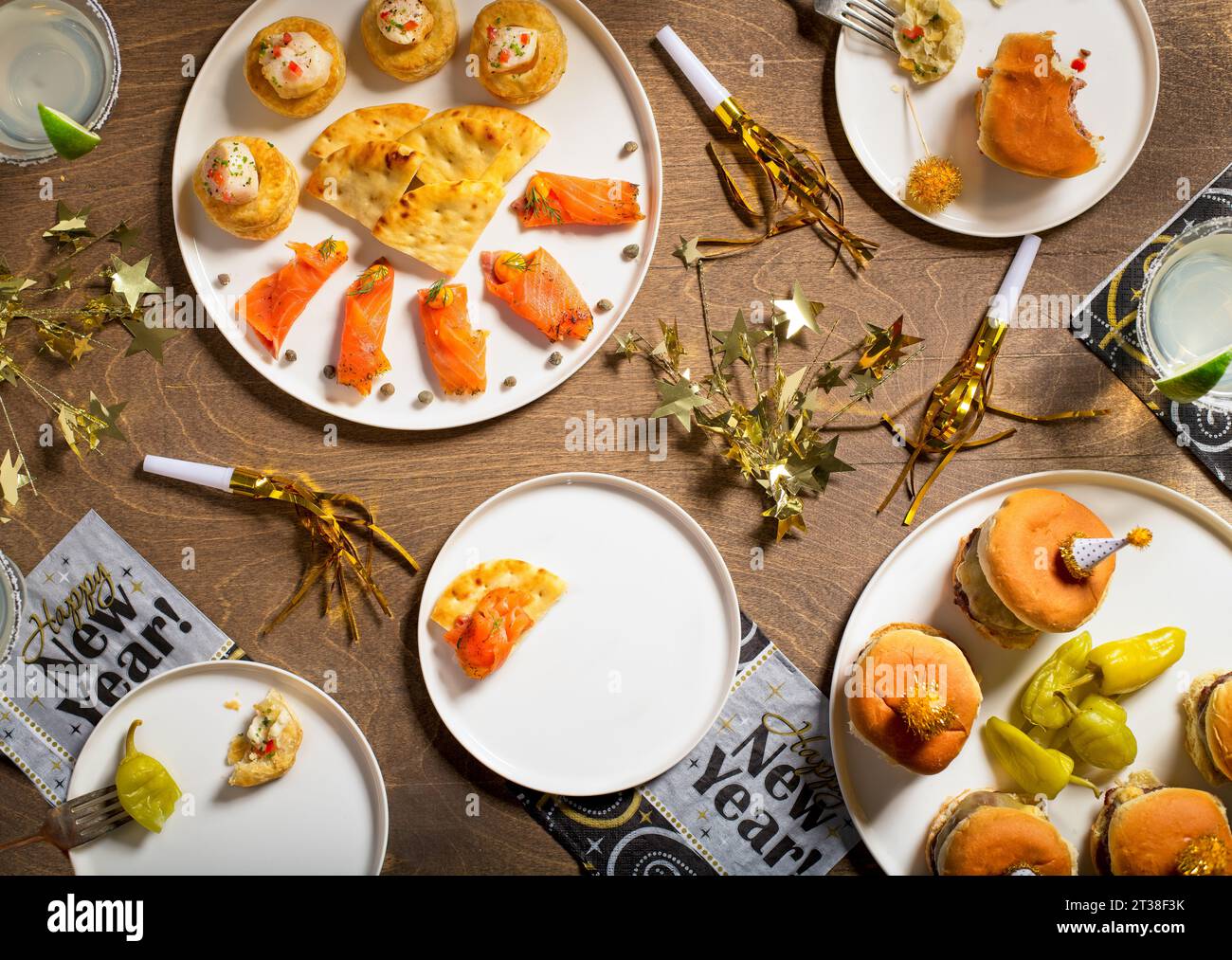 New Year's Eve meal with decorations. salmon, slider, peppers and a margarita on wooden table ...