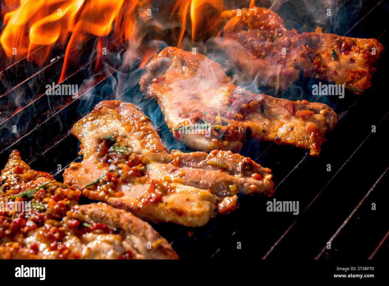 Pork cutlets angeled view on flamed grill Stock Photo - Alamy