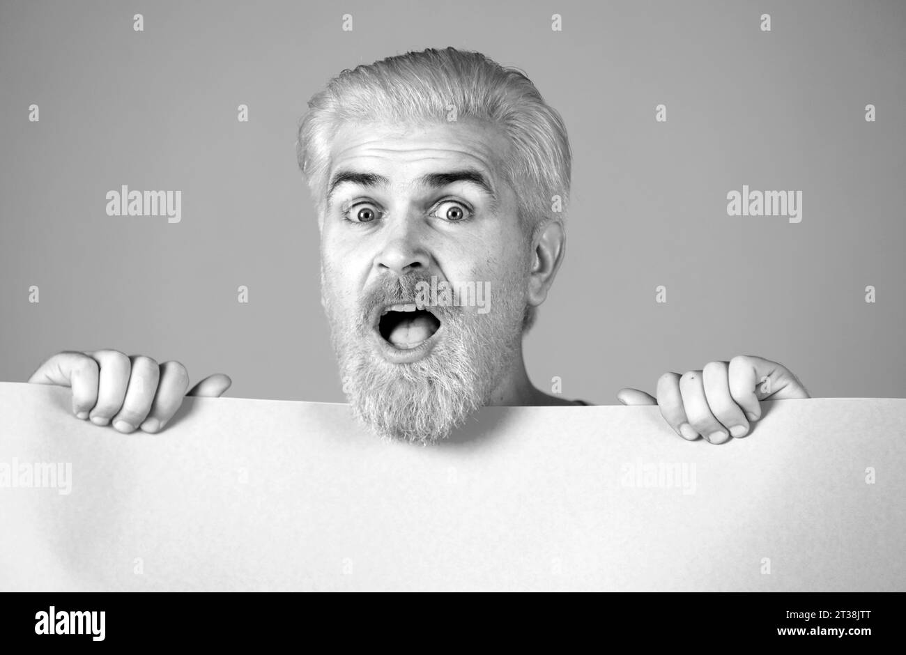 Excited Man with blank advertising board on color background. Business ...