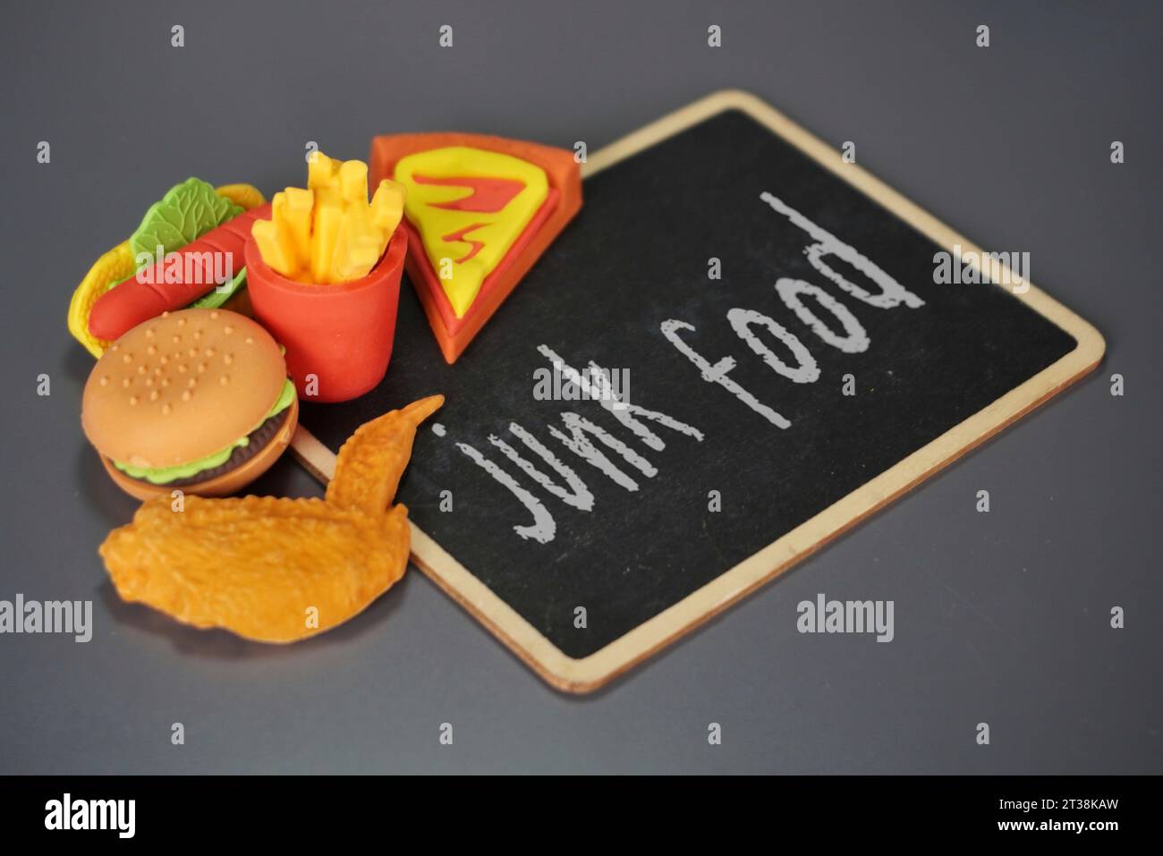 Closeup image of junk foods and chalkboard with text JUNK FOOD ...