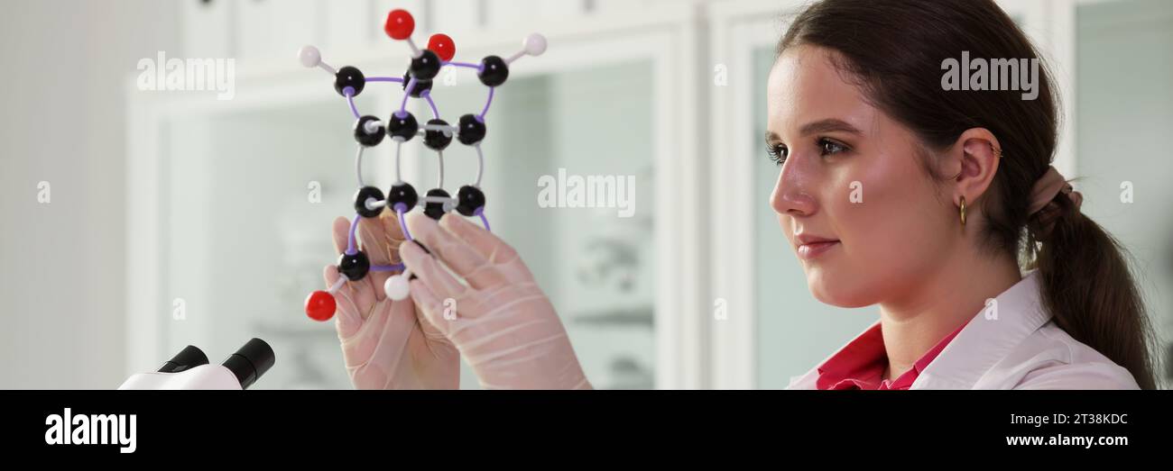 Laboratory worker in white coat examines model of molecule Stock Photo ...