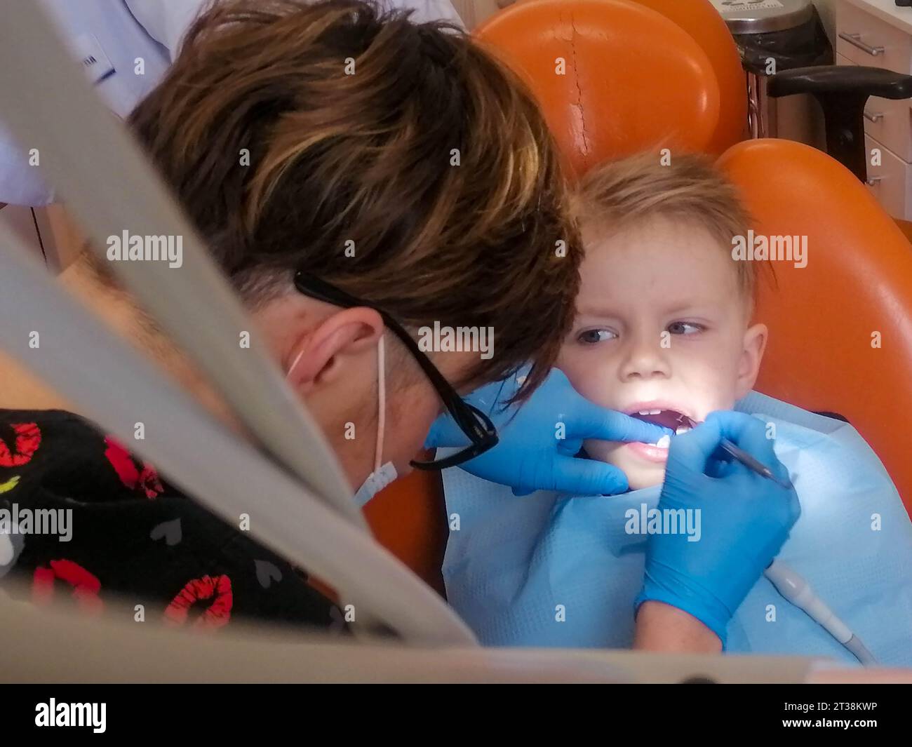 Female dentist examines the teeth of the patient cheerful child with ...