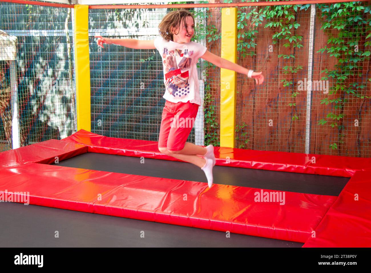 Happy girl having fun while jumping on trampoline. Sports girl jumps on ...