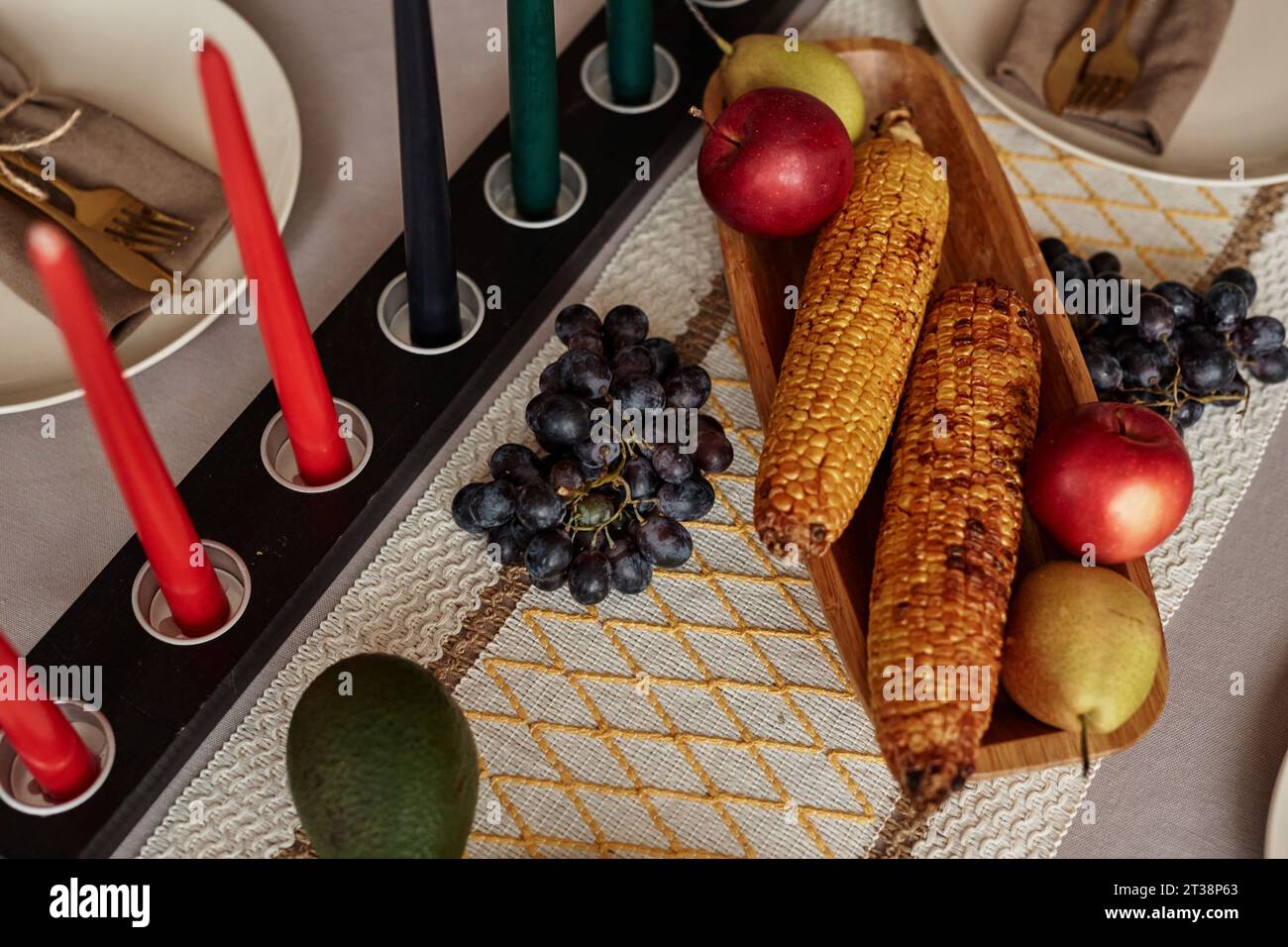 Colorful candles and muhindi ears of corn on table served for Kwanzaa ...