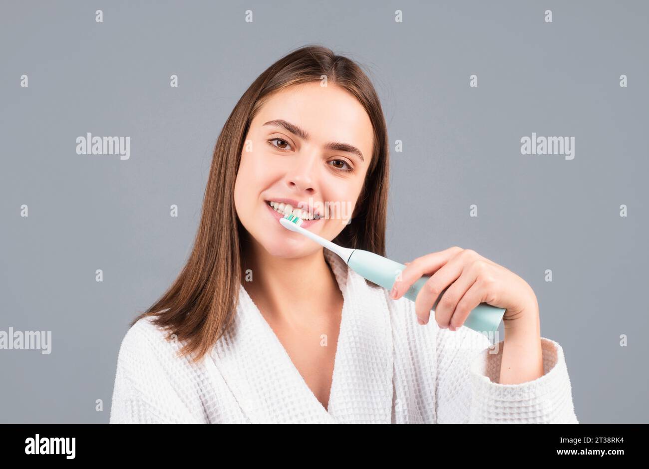 Smiling young woman brushing teeth using toothbrush with whitening ...