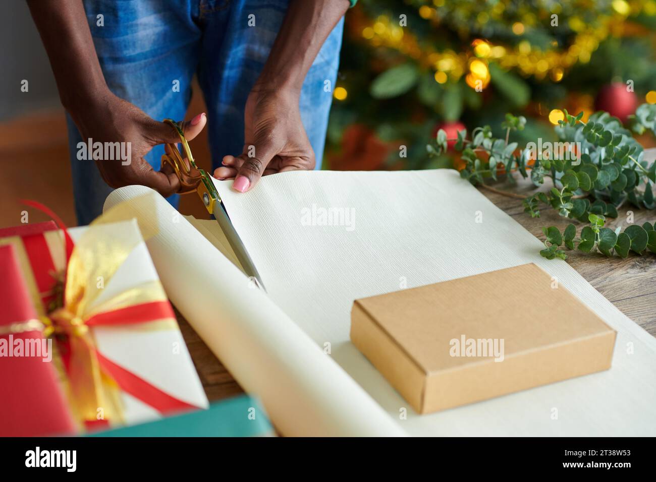 Hands of man cutting wrapping paper when decorating gift boxes for ...