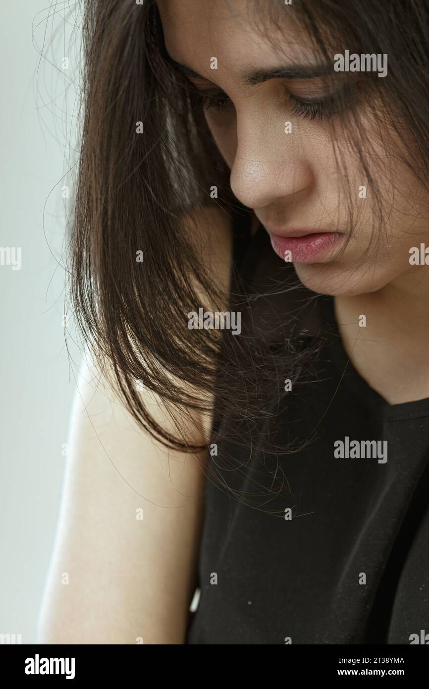 With downcast eyes and hunched shoulders, a young Indian lady exudes ...