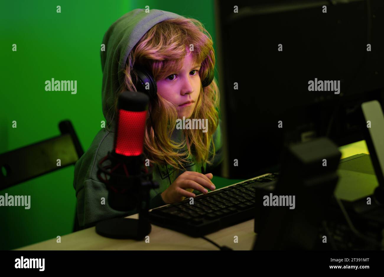 Little child gamer play computer game on desktop. Gaming stream and ...