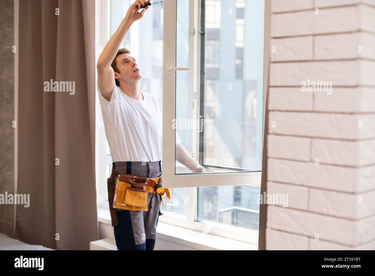 Construction worker installing window in house Stock Photo - Alamy