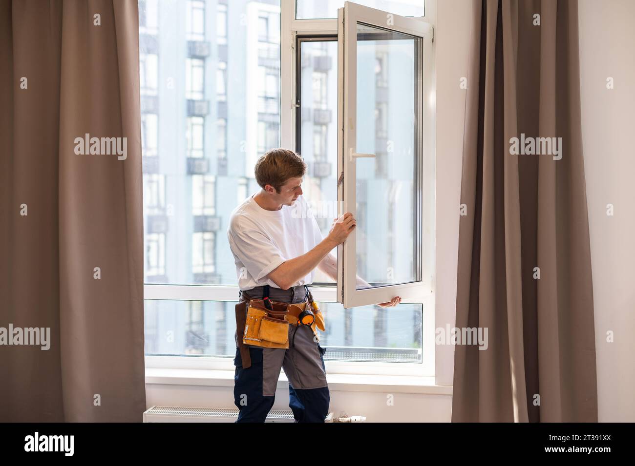 Construction worker installing window in house Stock Photo - Alamy