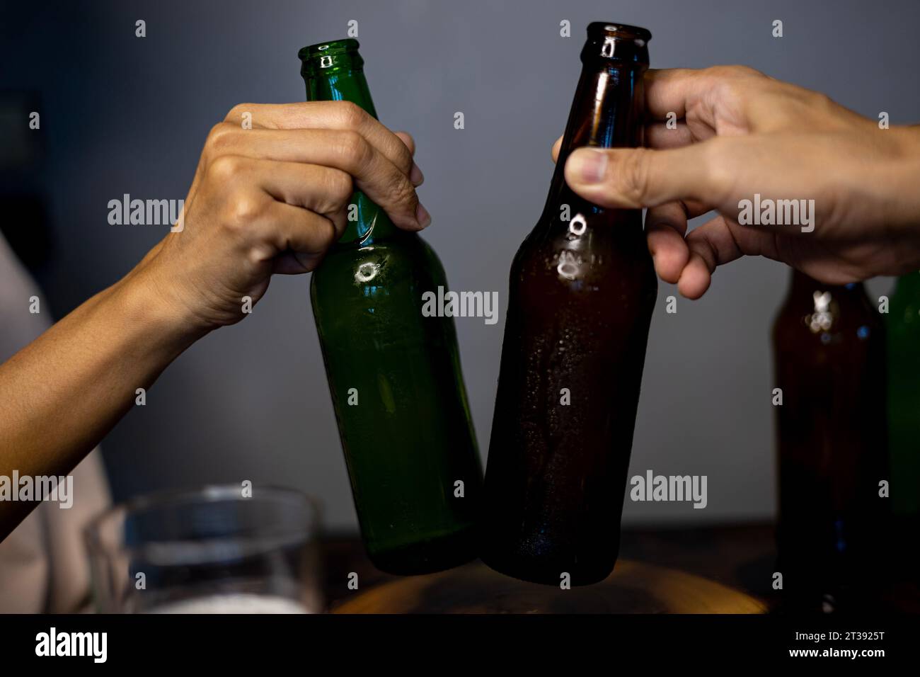 Two Friends Toasting With Bottle Of Light Beer. Hands lifting two beer ...