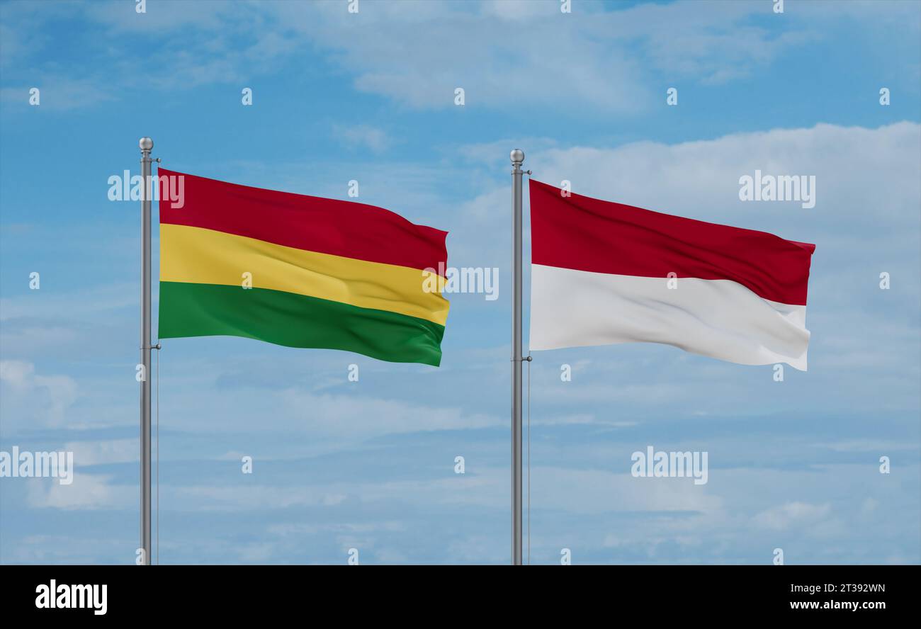 Indonesia and Bolivia flags waving together on blue cloudy sky, two ...
