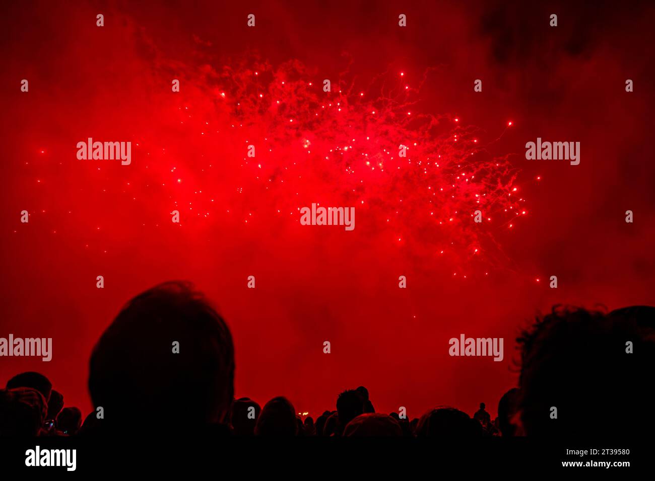 Silhouetted people watching a fireworks display in Lewes, East Sussex ...