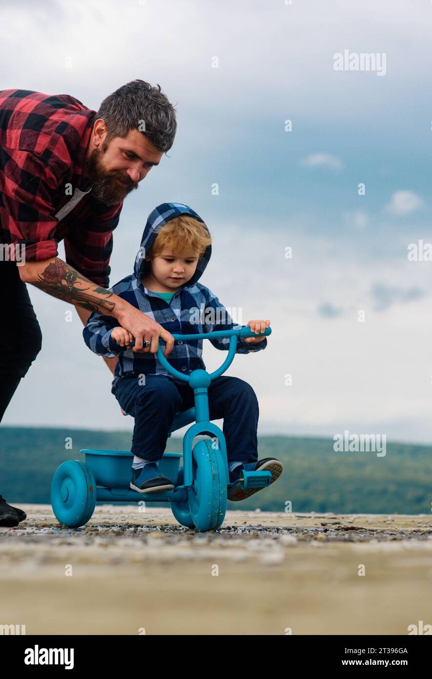 Father teaching his son to ride a bicycle. Little boy learn to ride a ...