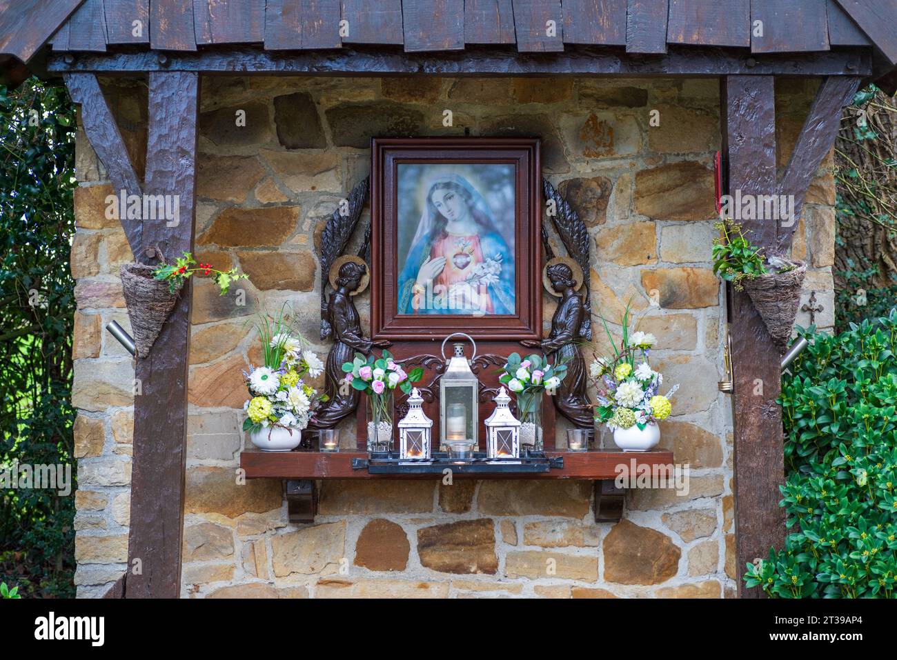 small outdoor chapel with candles and a maria painting Stock Photo - Alamy