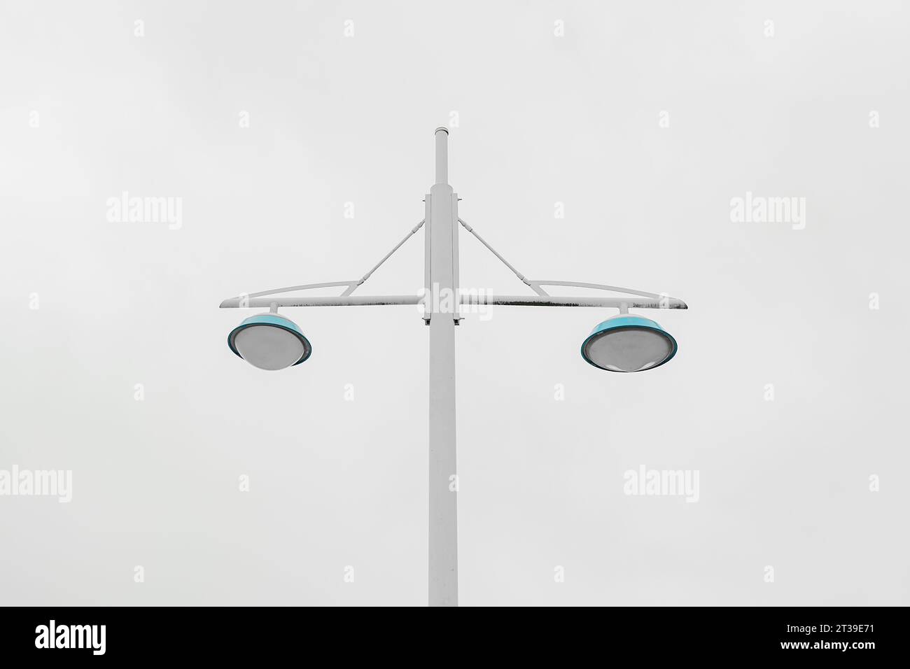 A minimalist shot of a dual-headed streetlight against a clear ...
