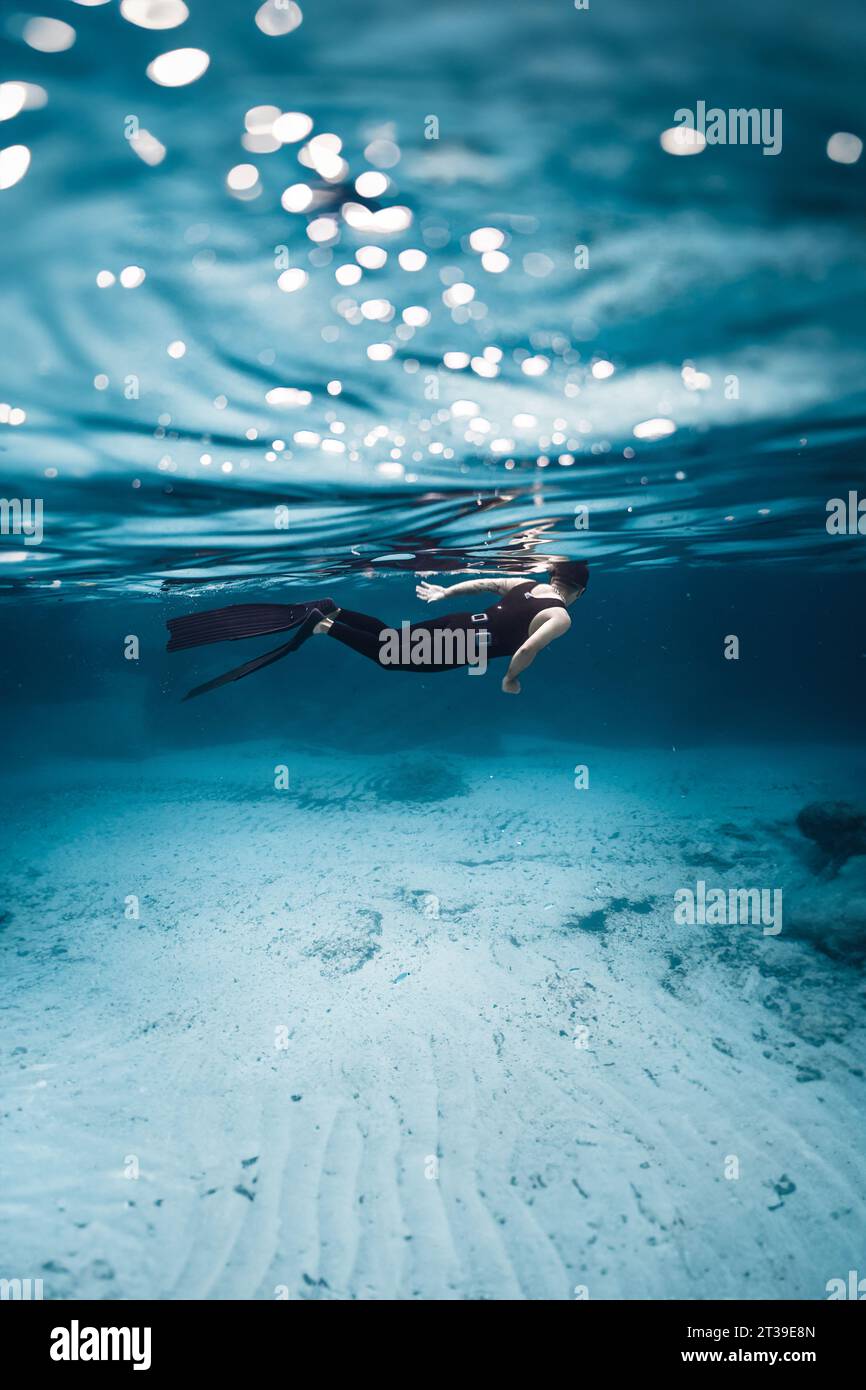 Photo of an underwater scene of a man wearing a snorkel mask swimming ...