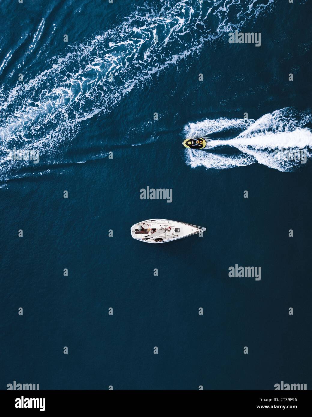 Top drone view of trails on water surface behind fast moving white ...